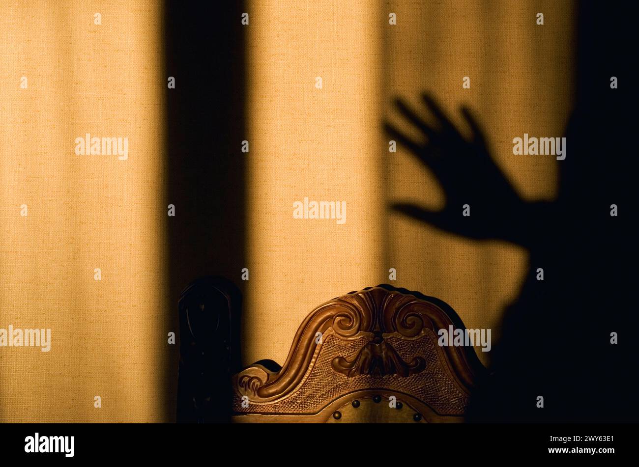 shadow of an ghand and curtain behind a chair Stock Photo - Alamy