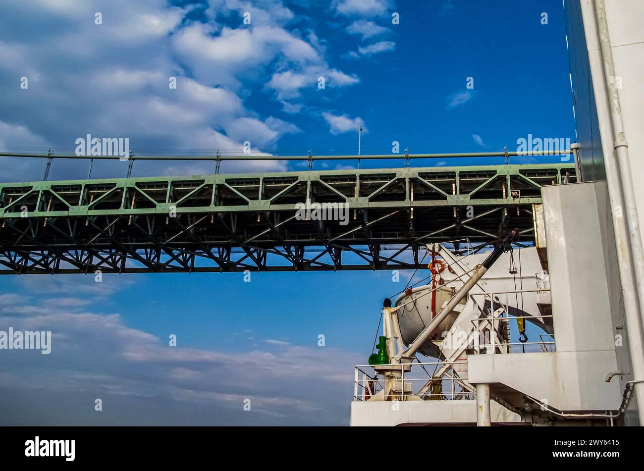 A large cargo ship passing under the bridge, photograph taken from the ...