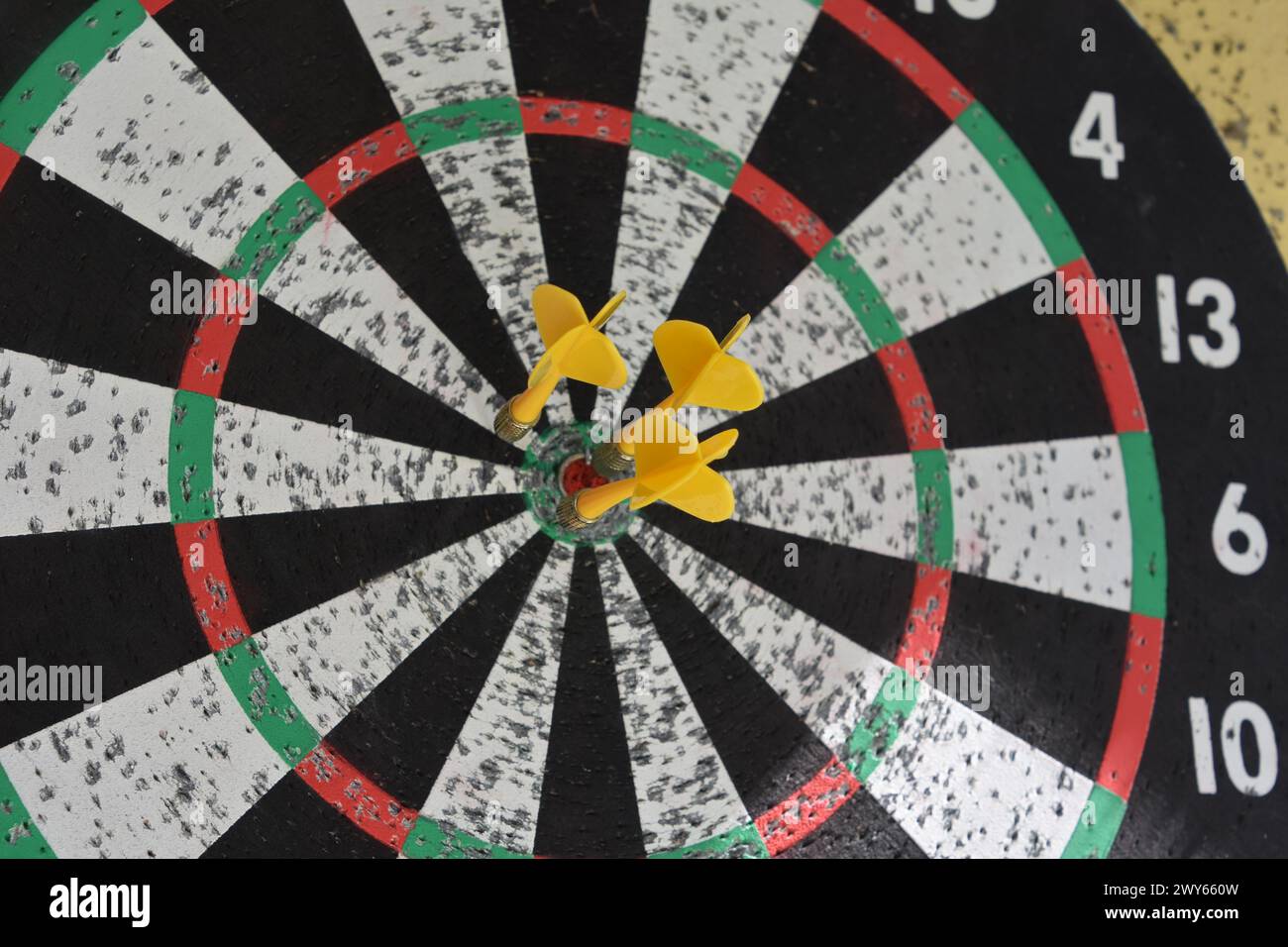 Trio of yellow darts targetted in the center of a dartboard Stock Photo ...