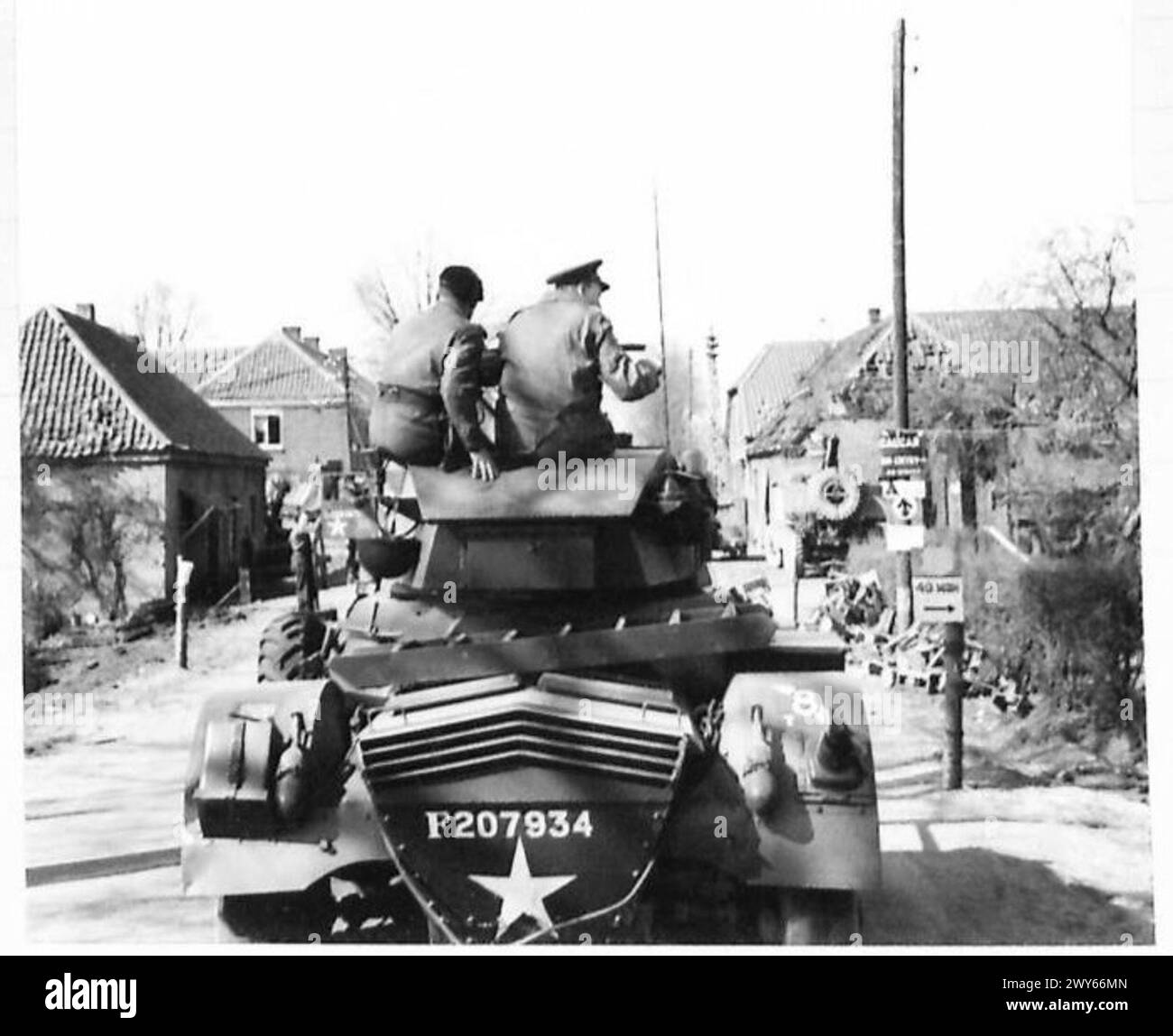 British Army units pass through a village on the Xanten-Calcar Road ...