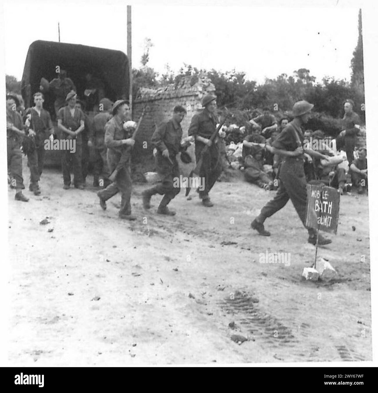 British infantrymen arrive at a mobile bath unit from forward positions ...