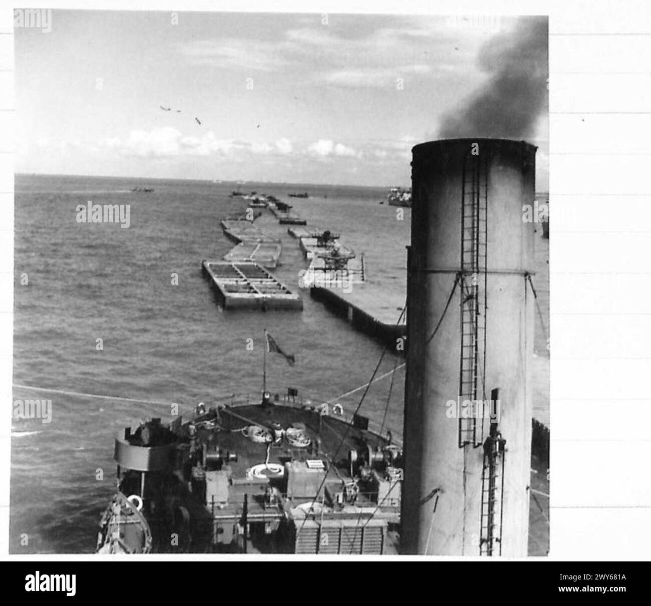 A line of prefabricated breakwater units is installed and sunk in ...