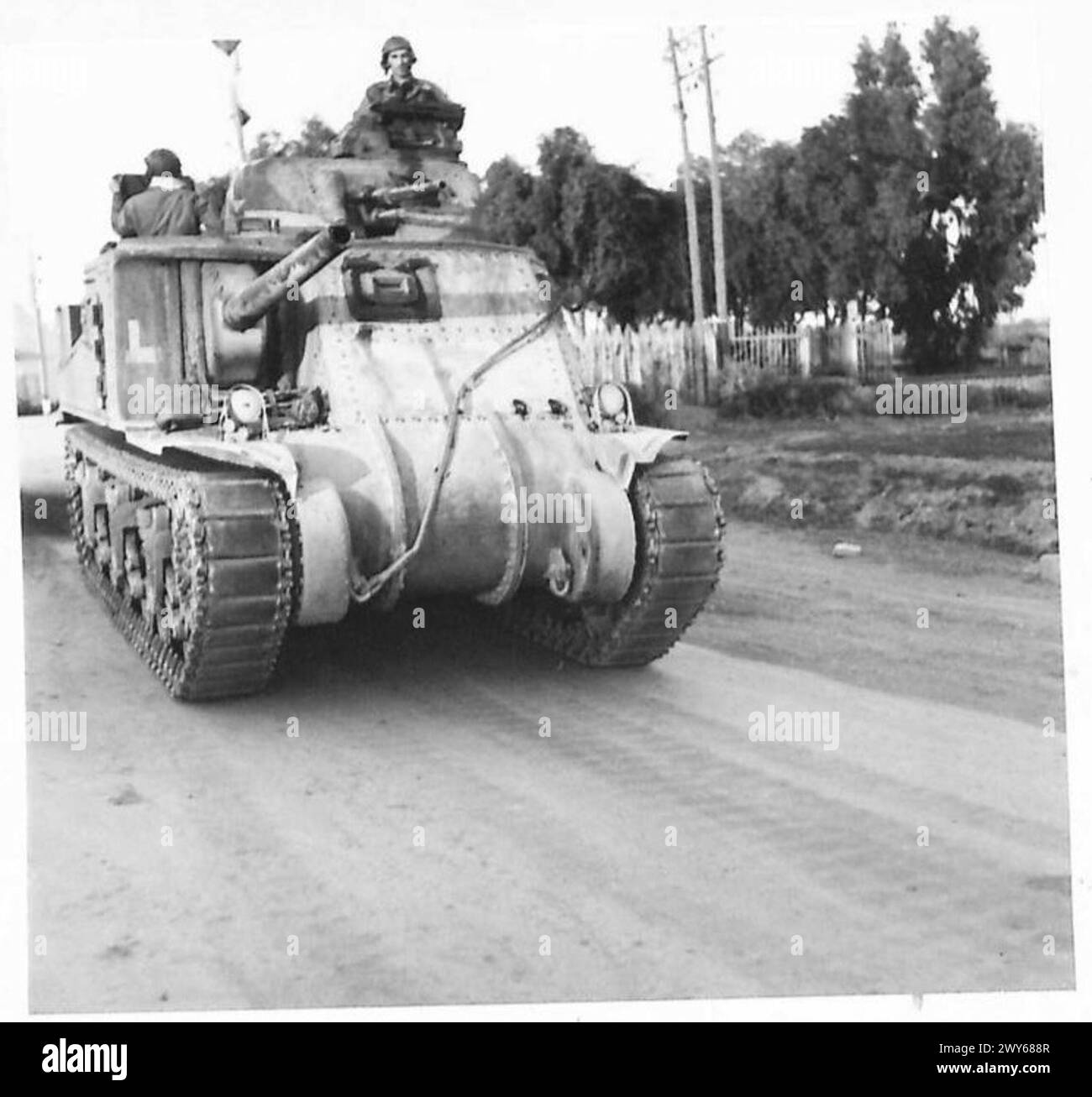 An American M3 Lee medium tank passes a knocked-out German Panzer III ...