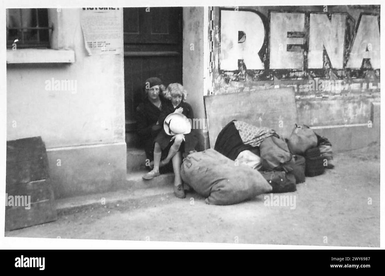 EVACUATING THE PEOPLE OF CAEN - A woman and her small daughter sit in a ...
