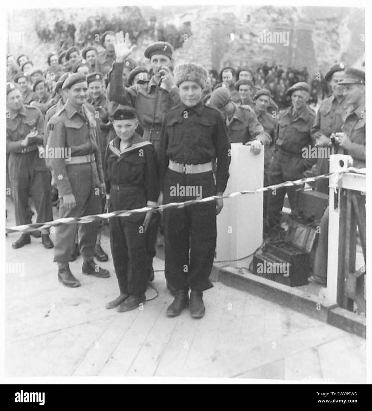 Victor and a friend wait at a displaced persons camp for the opening of ...