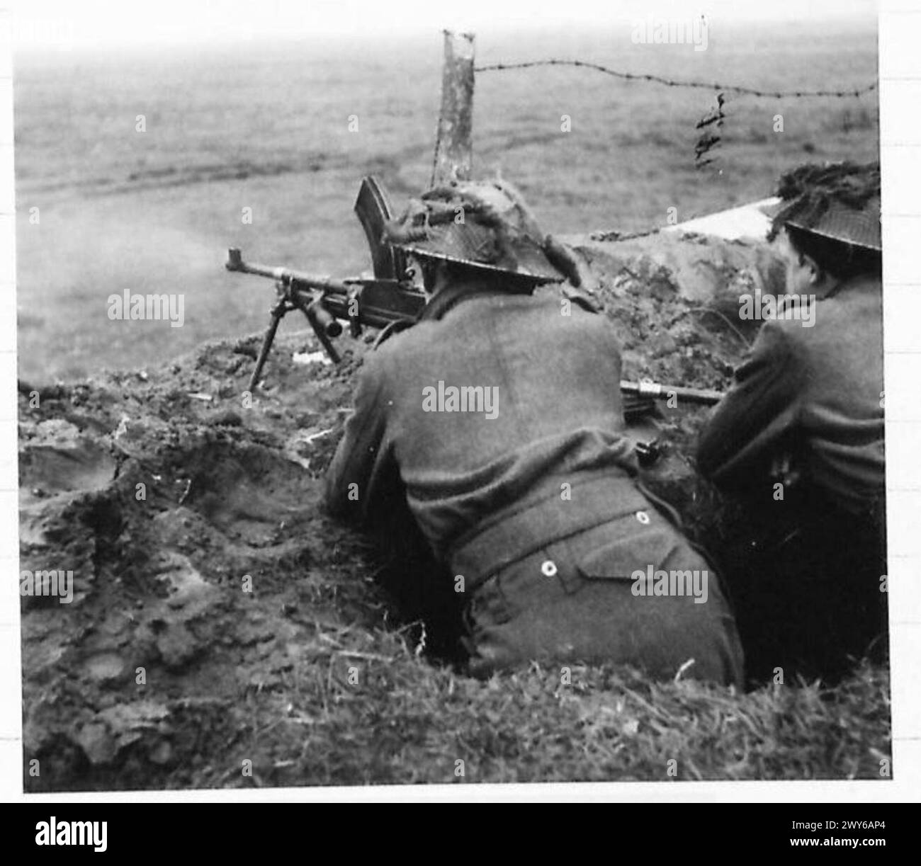 A British Bren gunner fires bursts of machine-gun fire to provide ...