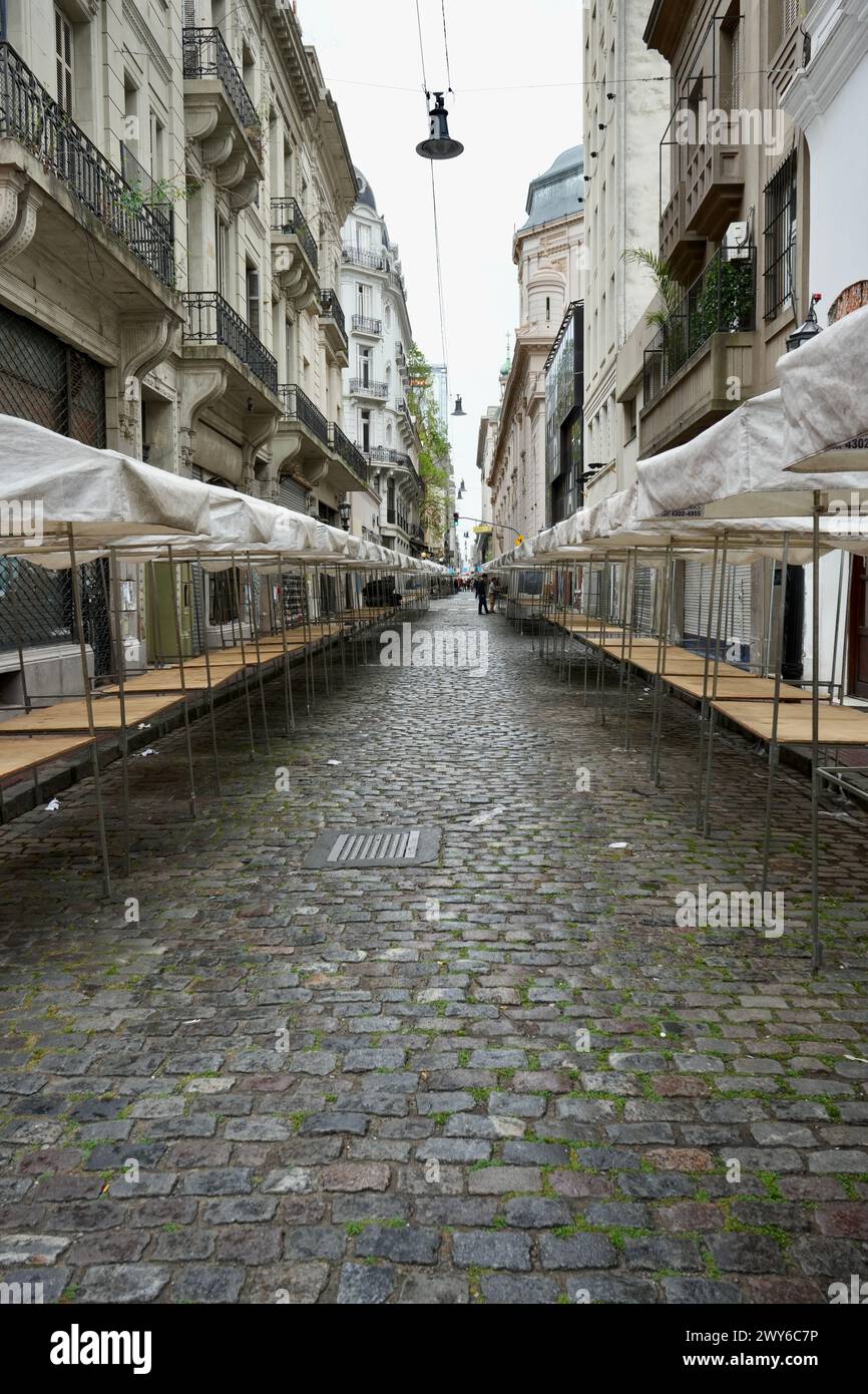 A street market being set up in a cobbled side street with colonial ...