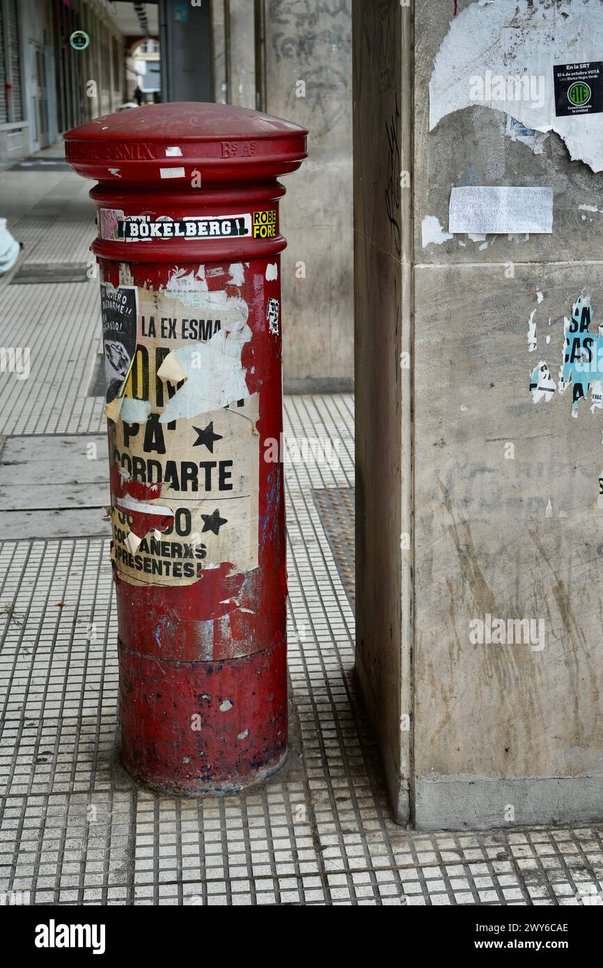 Vintage red post box covered in posters Stock Photo - Alamy