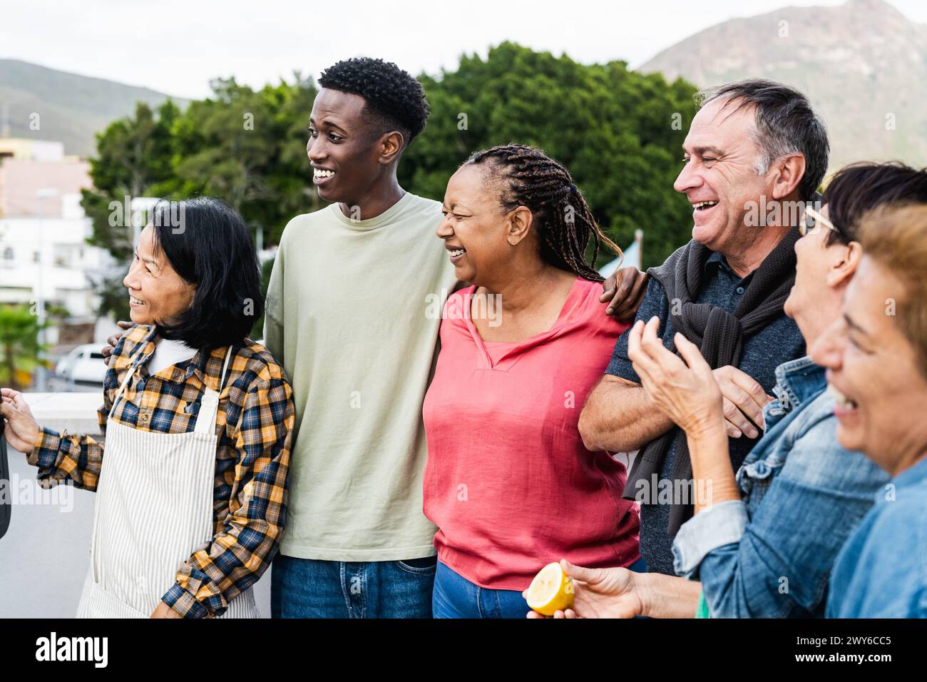 Happy multigenerational friends having fun preparing food at house ...