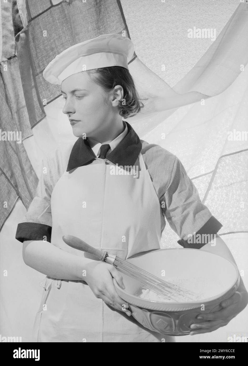 A Wren cook is photographed working in the galley as part of Royal Navy ...
