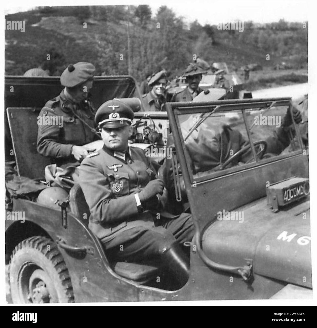 A German colonel is transported by jeep to Corps Headquarters in a ...