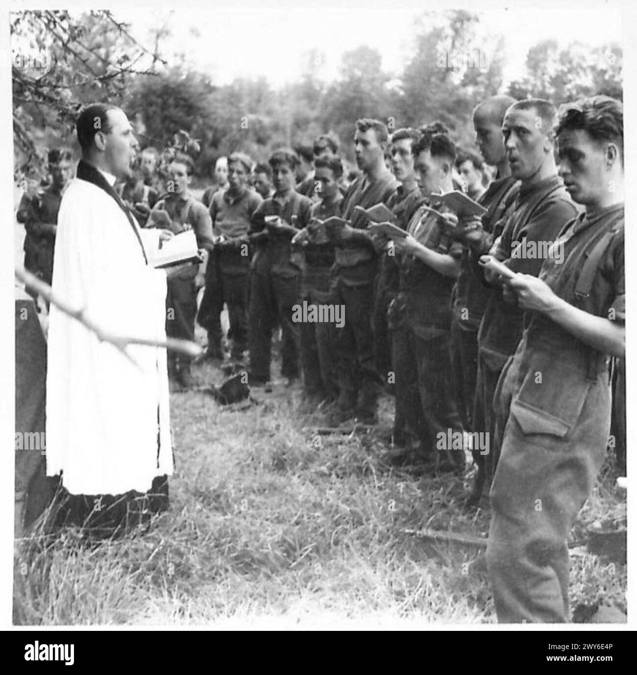 Reverend S. Cook conducts an open-air service for a battalion of the 9 ...