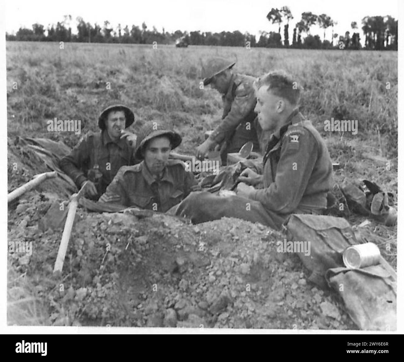 Soldiers of the 49th Division, Durham Light Infantry, take a hasty meal ...