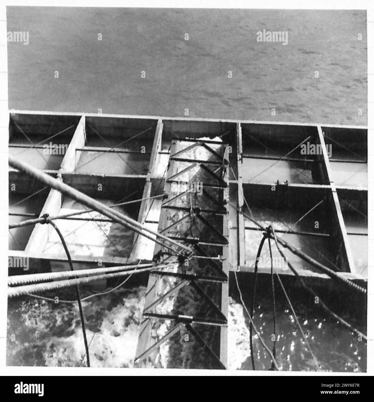 Photographs show a trough from a dredger being used to fill a ...