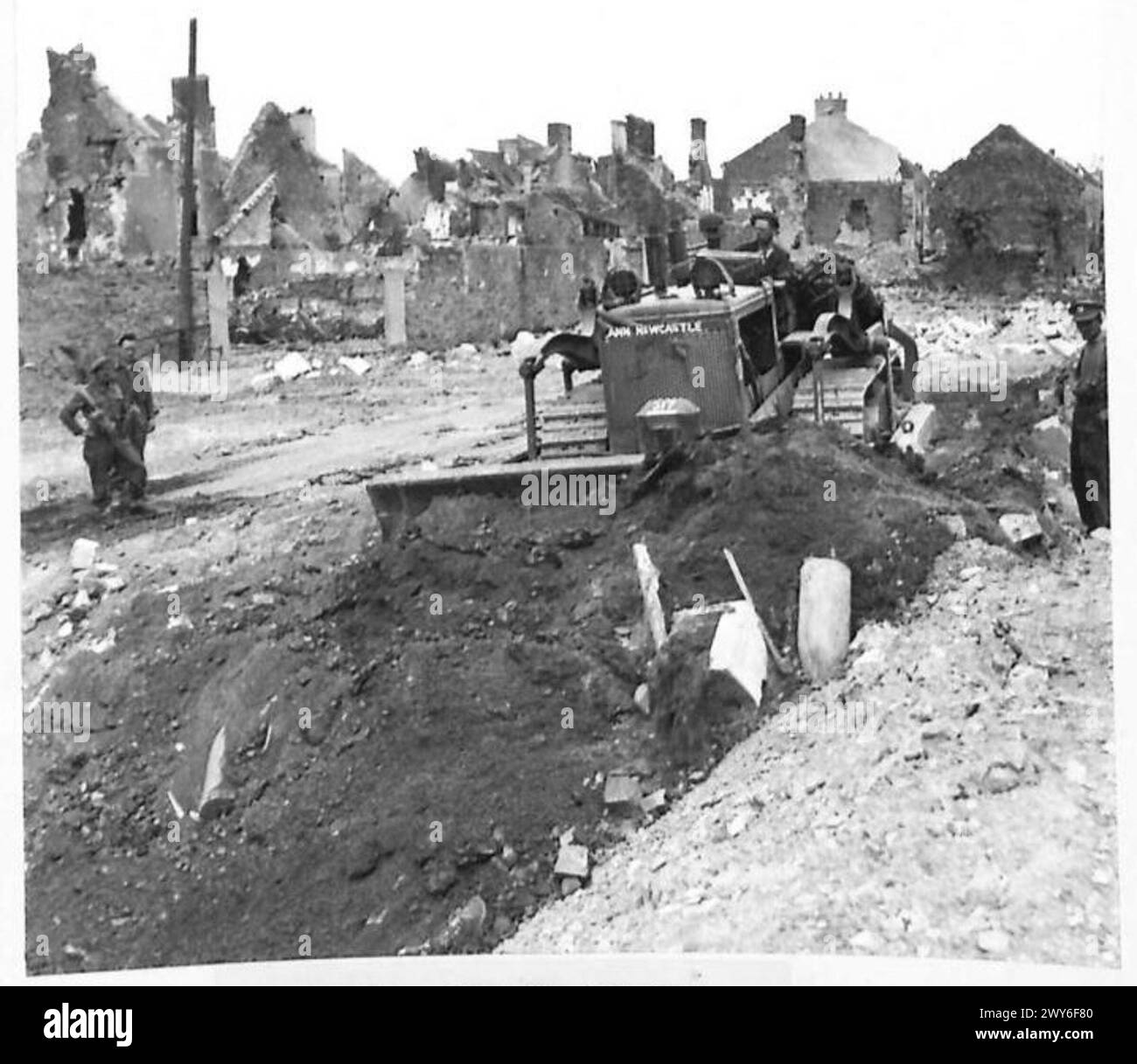 VILLERS BOCAGE CAPTURED BY BRITISH - A bulldozer filling in a bomb ...