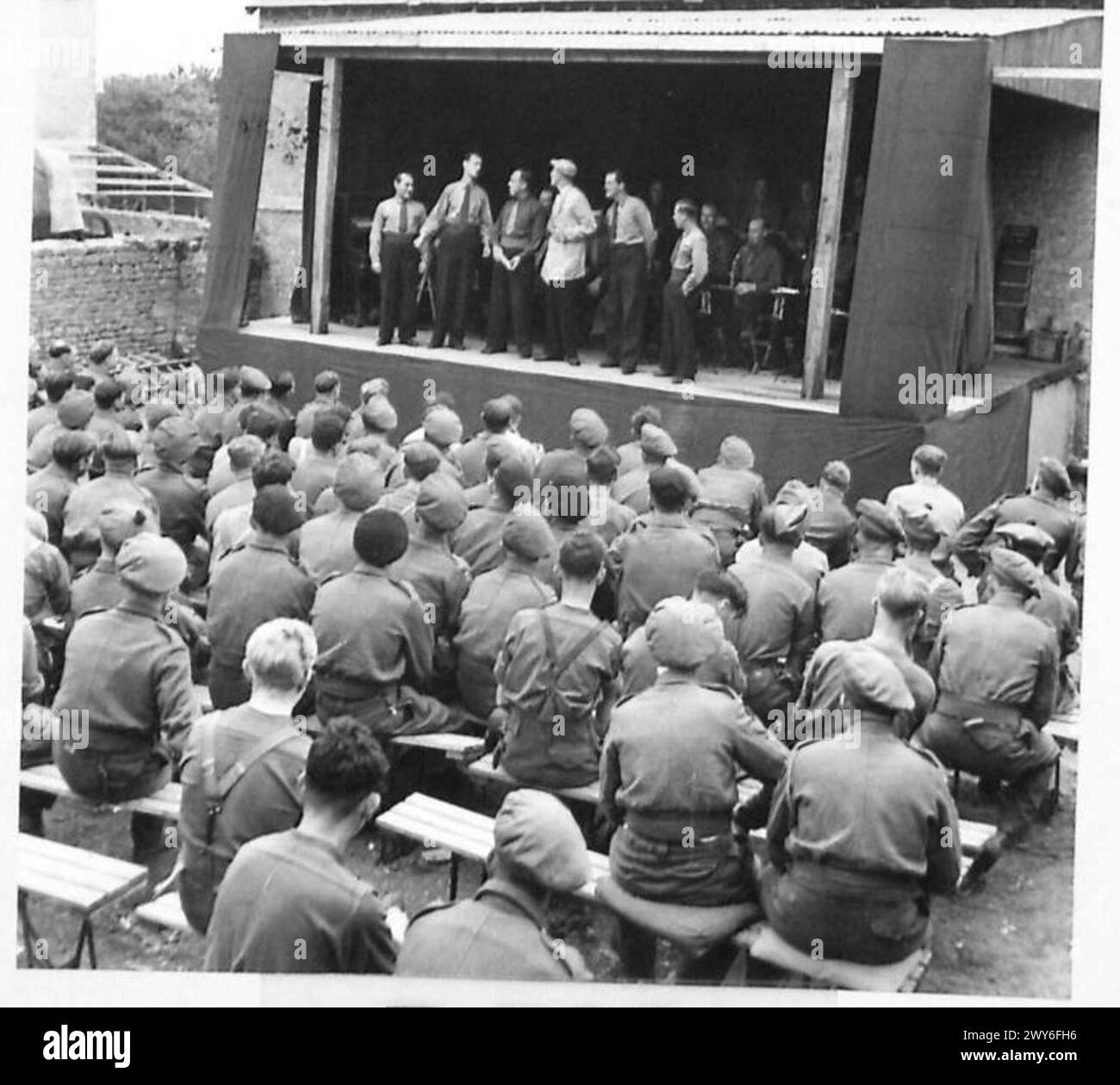 An Army Concert Party performs from a temporary stage beside a ...