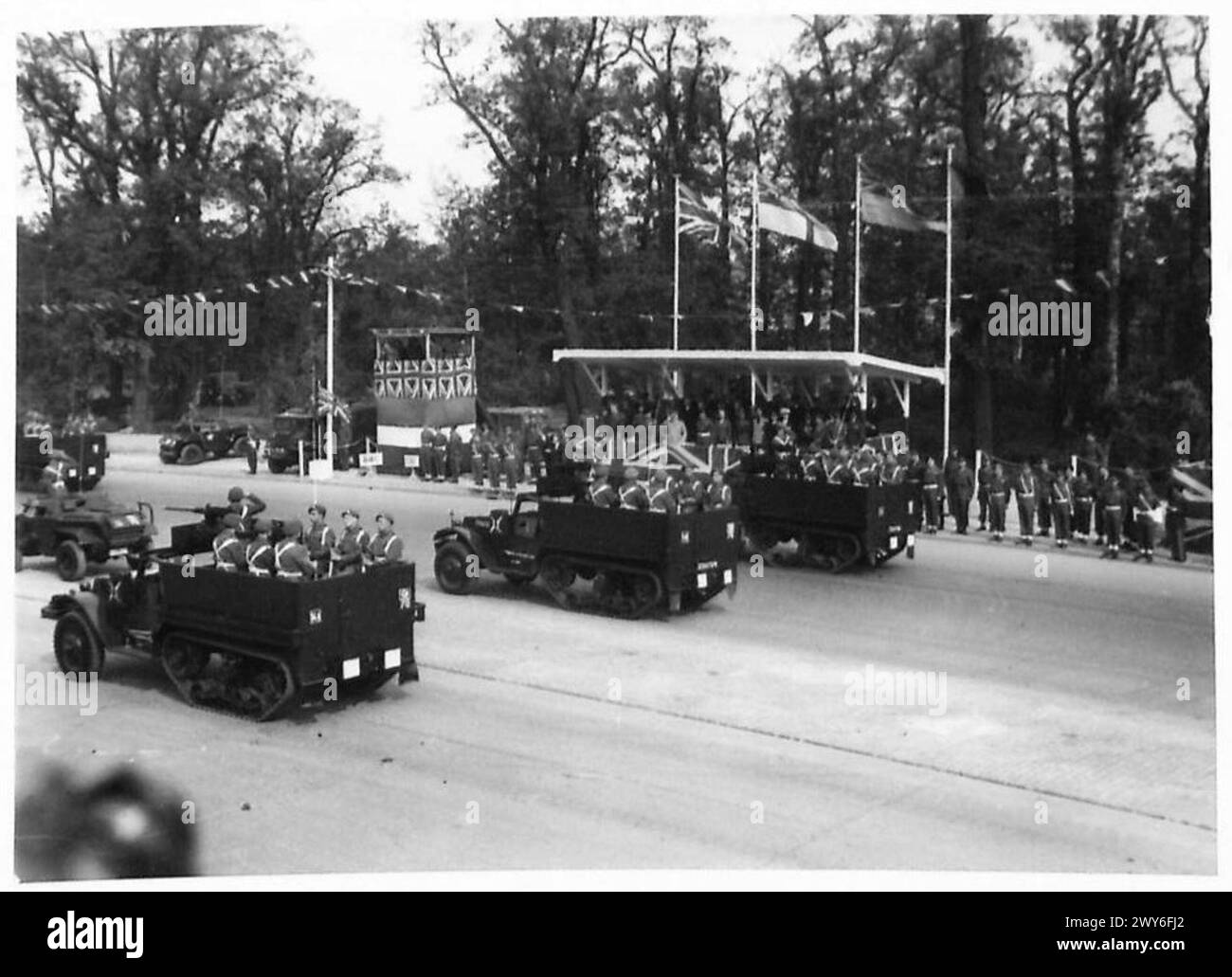 British Army half-track vehicles pass a saluting base during the ...