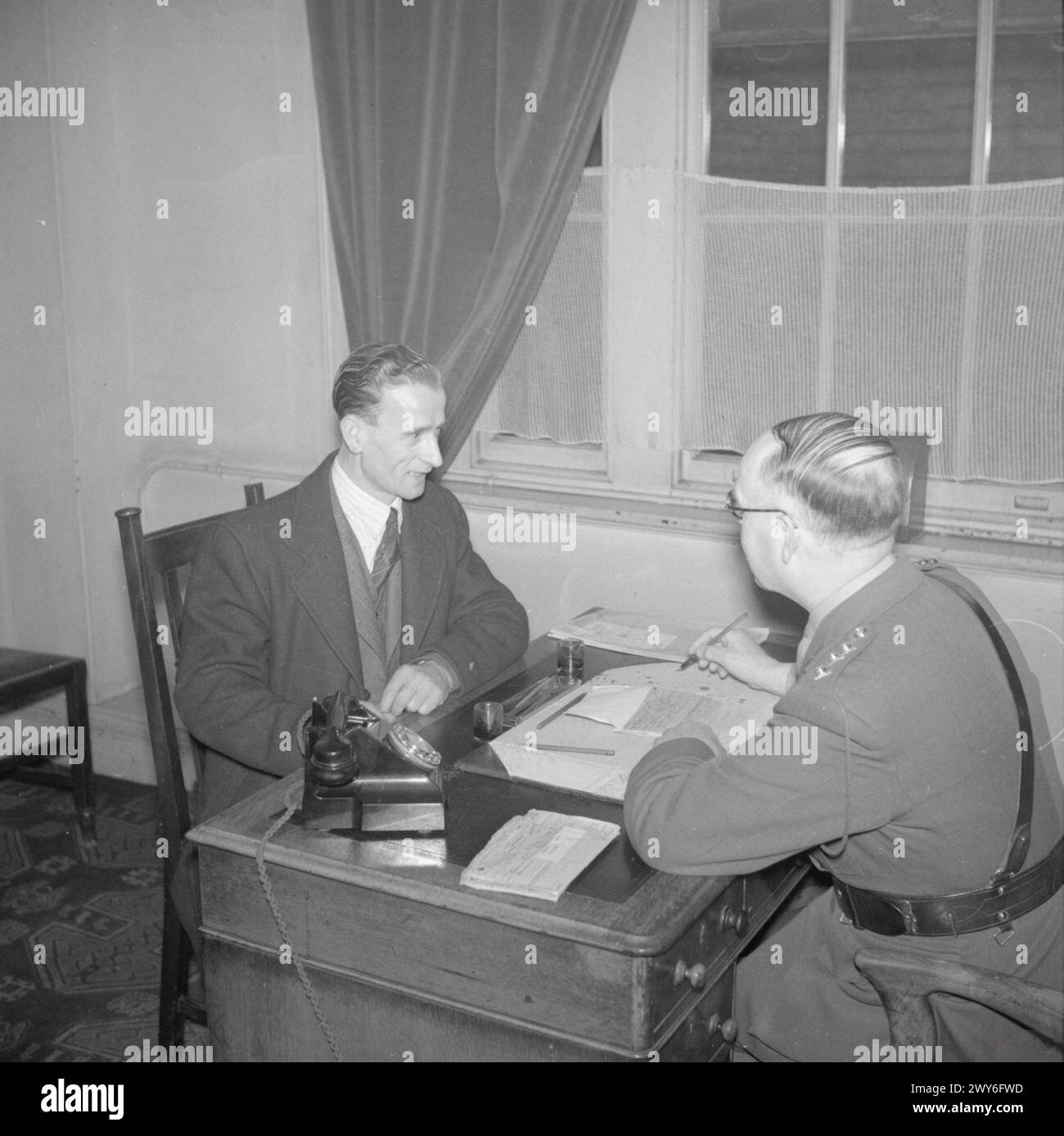 A prospective recruit is interviewed by a commanding officer at the ...