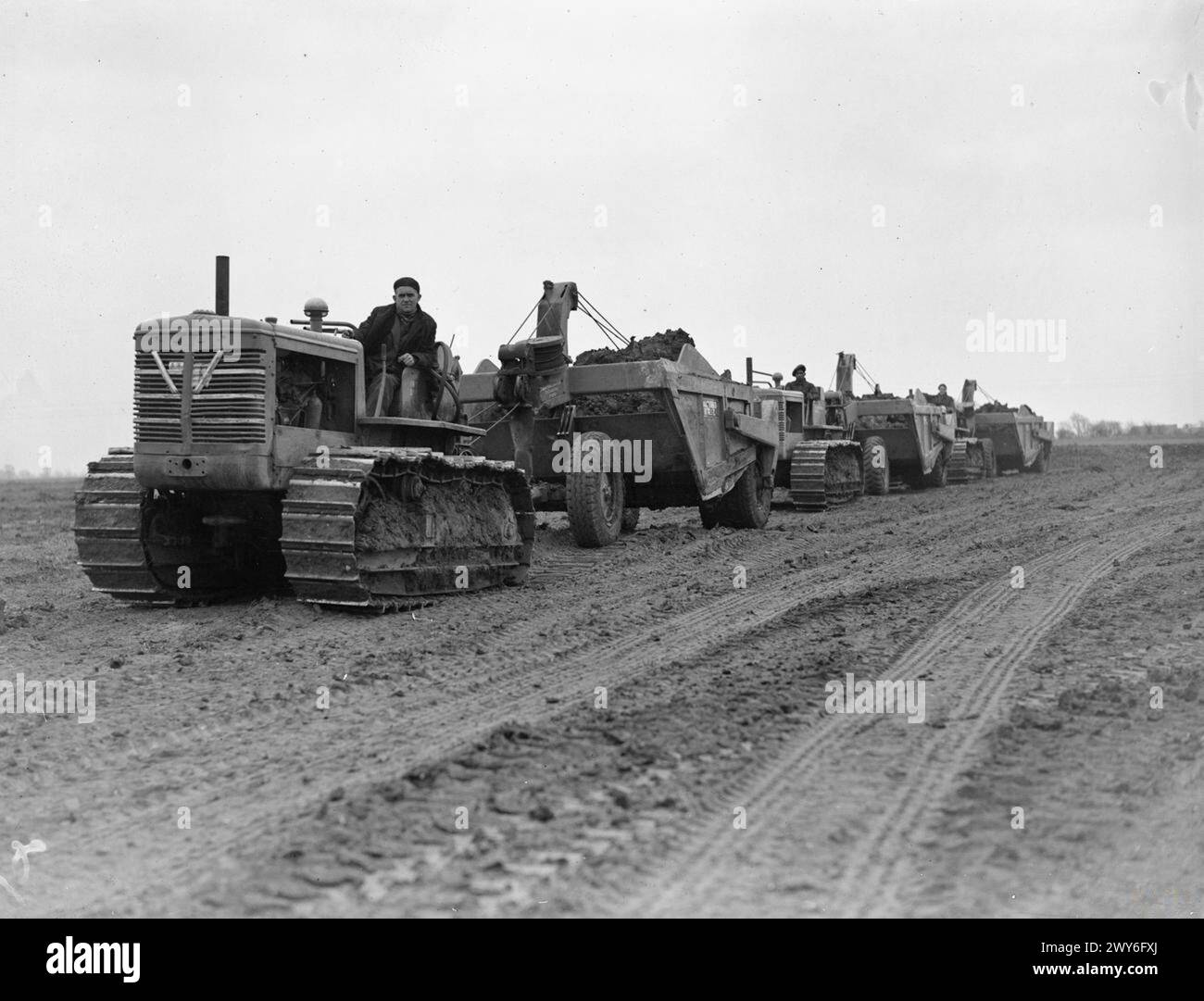 Three bulldozers level the ground with scrapers for the construction of ...