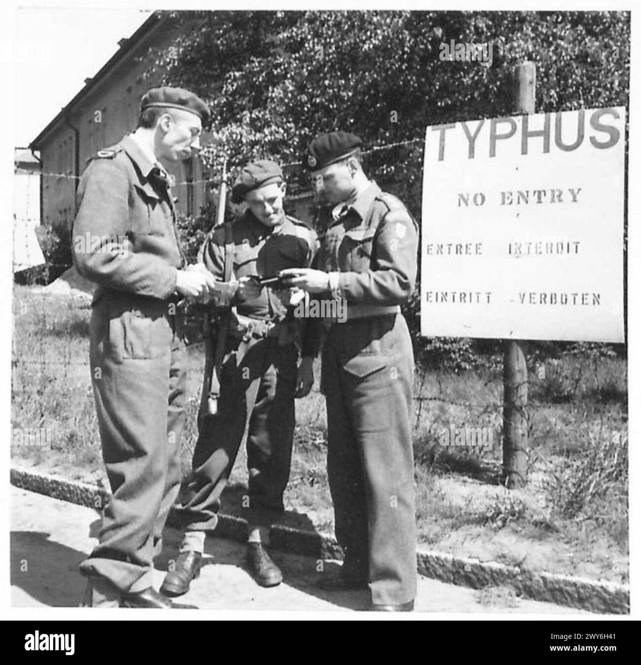 Two officers, including Captain W.J. Clayton, present passes to a ...