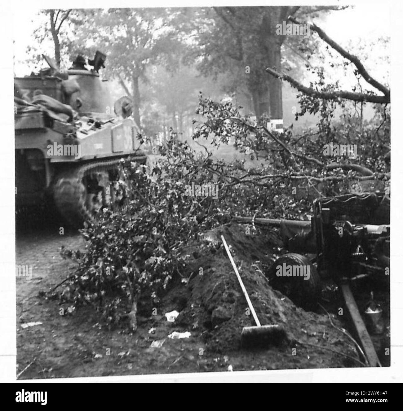 British 53rd Division tanks advance past an anti-tank gun guarding the ...