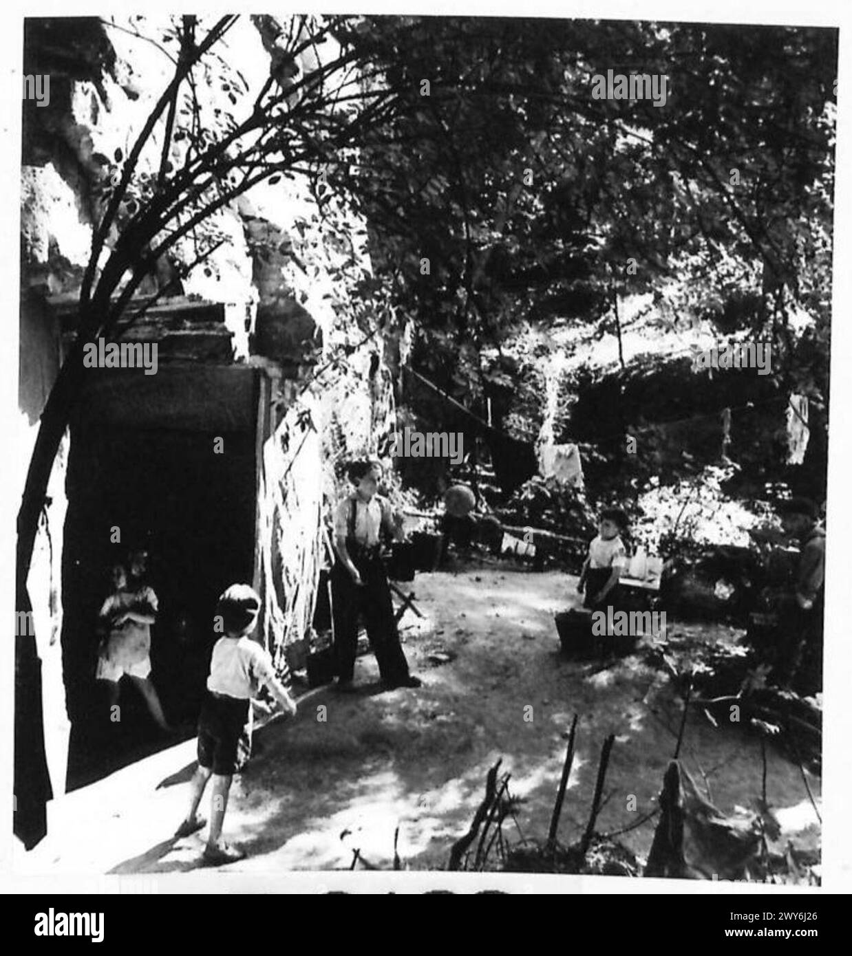 Children of families displaced by bombing in Caen play outside caves ...