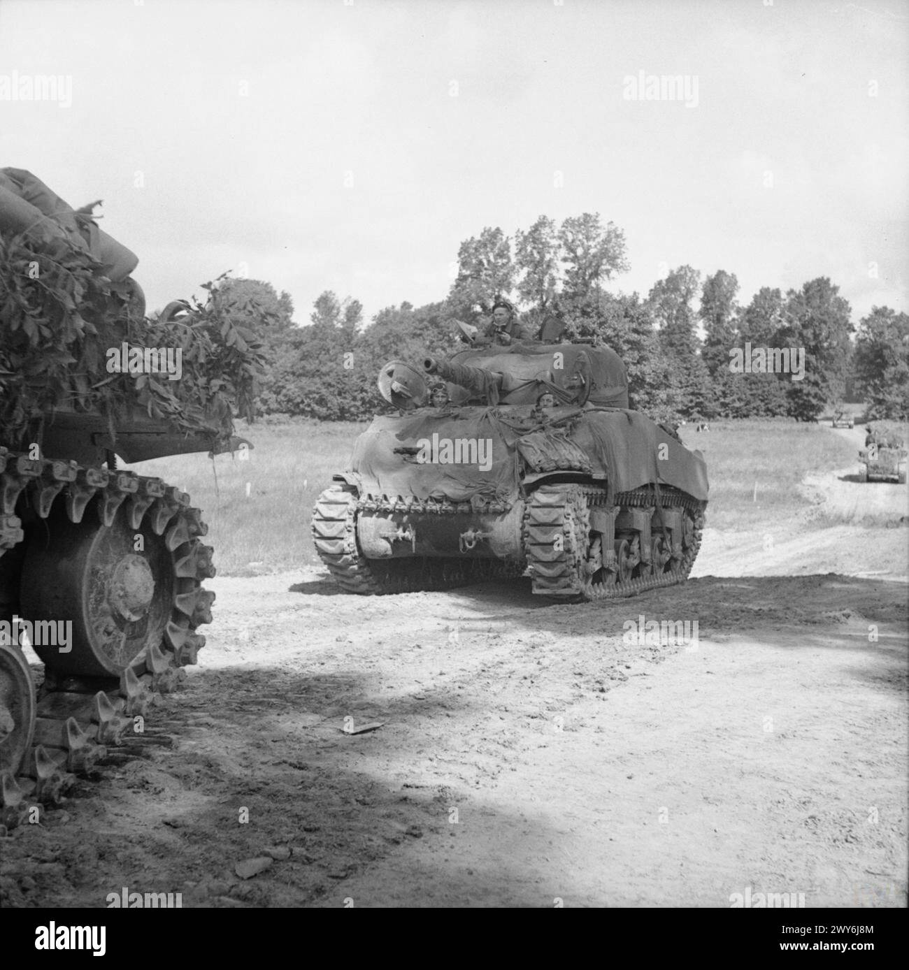 THE BRITISH ARMY IN NORMANDY 1944 - Camouflaged Sherman tanks moving up ...