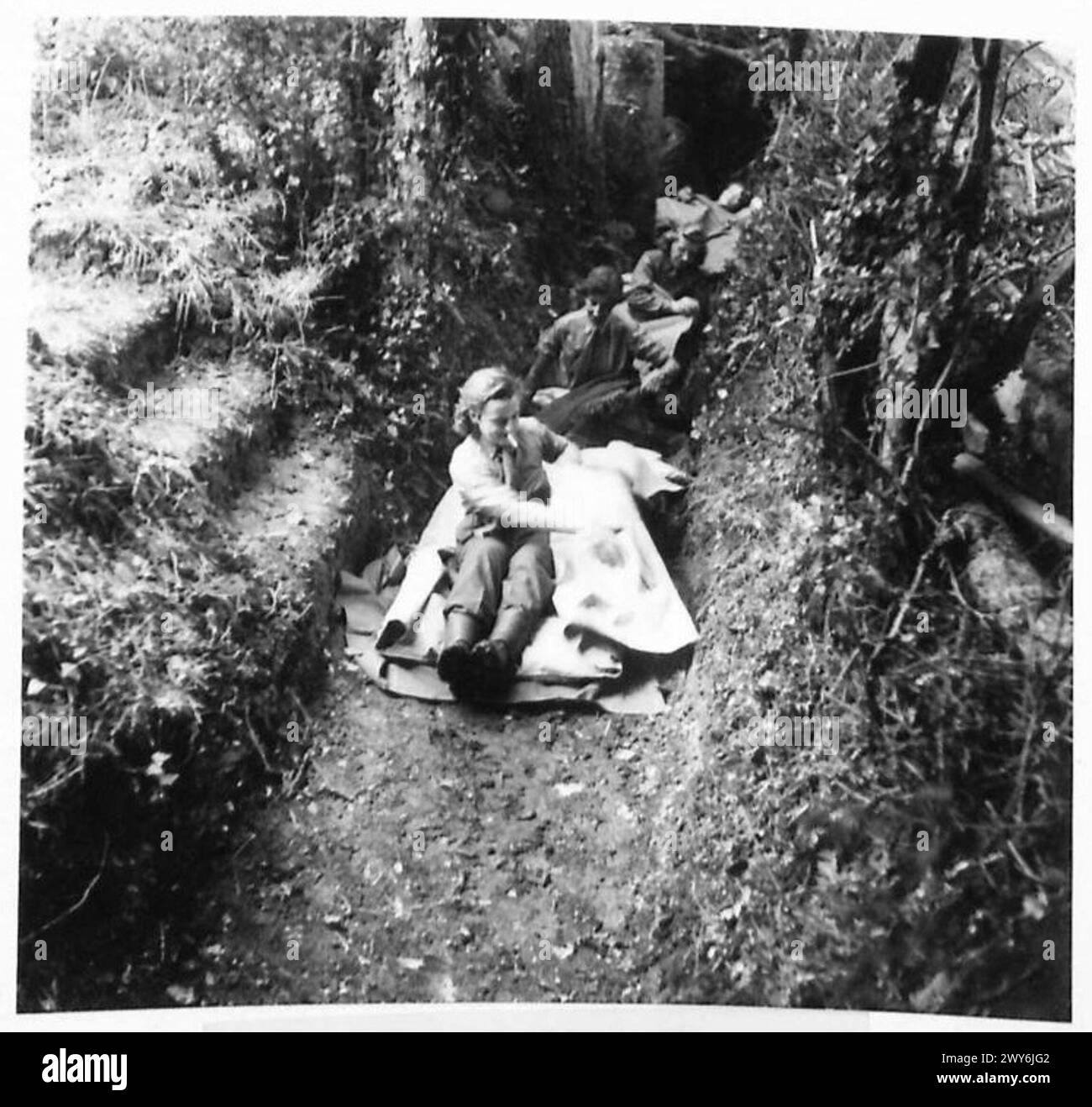 Female medical personnel prepare beds in a slit trench to ensure safety ...