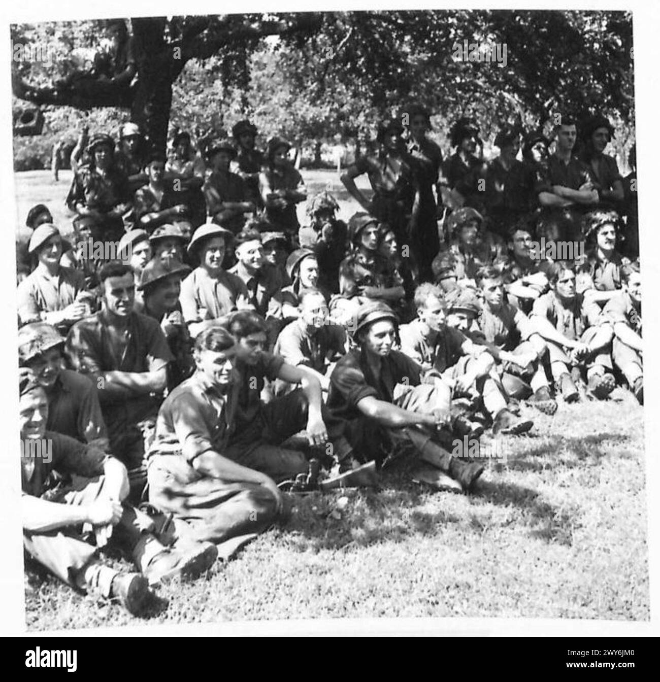 GEORGE FORMBY ENTERTAINED TROOPS IN NORMANDY - George Formby standing on a jeep entertaining the ...