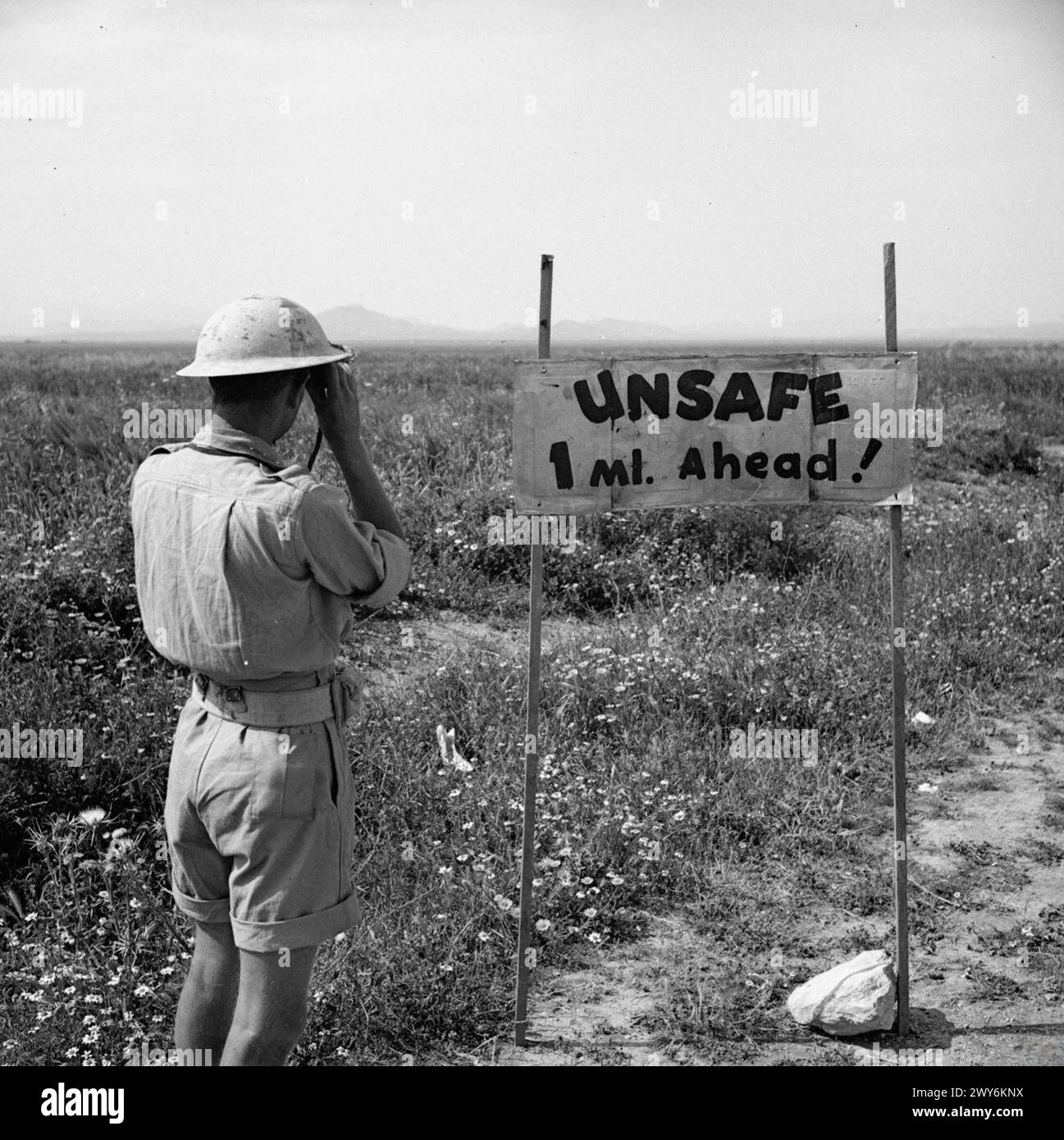 Photograph shows Sergeant Brailey of the 8th Army observing hills from ...