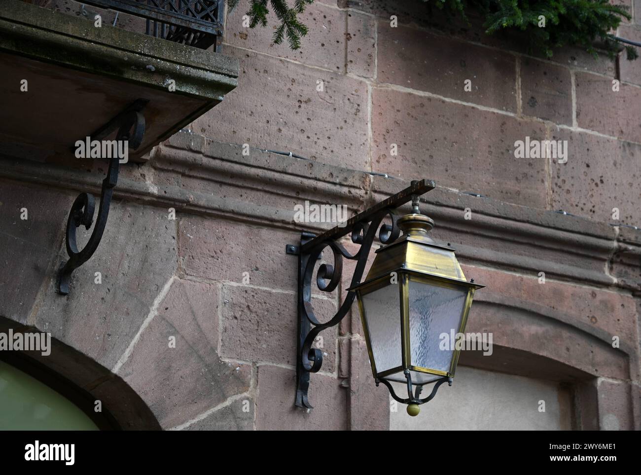Antique brass wall lantern on the exterior of a half-timbered building ...