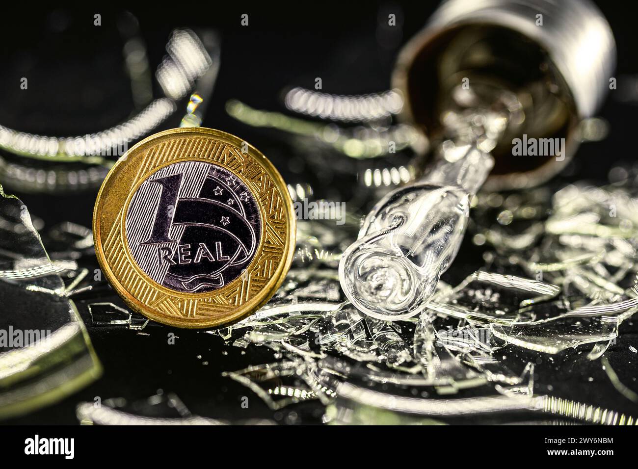 one real coin with a broken light bulb, concept of high cost of ...