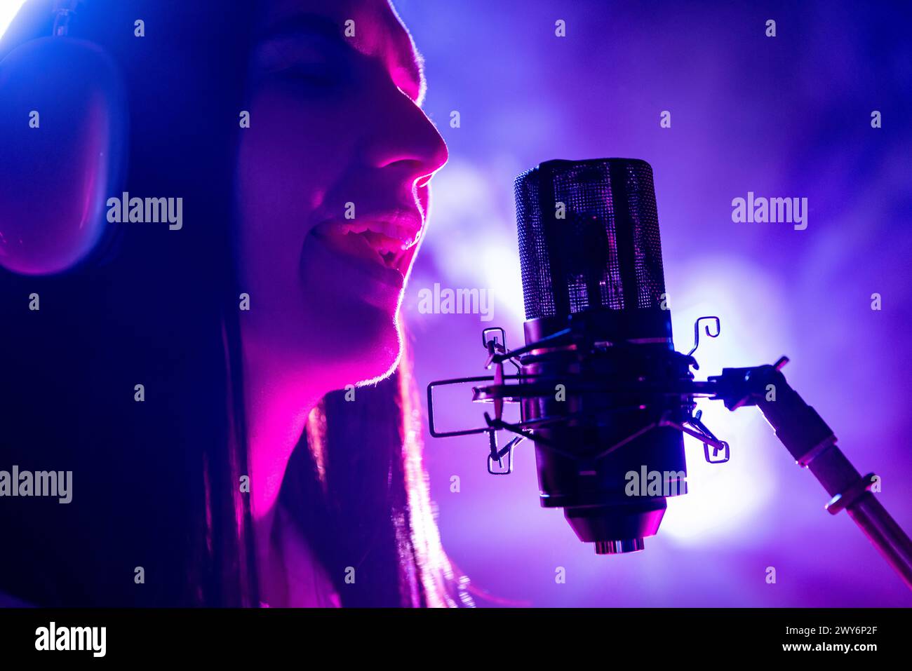 Close up portrait of music artist singing into condenser microphone ...