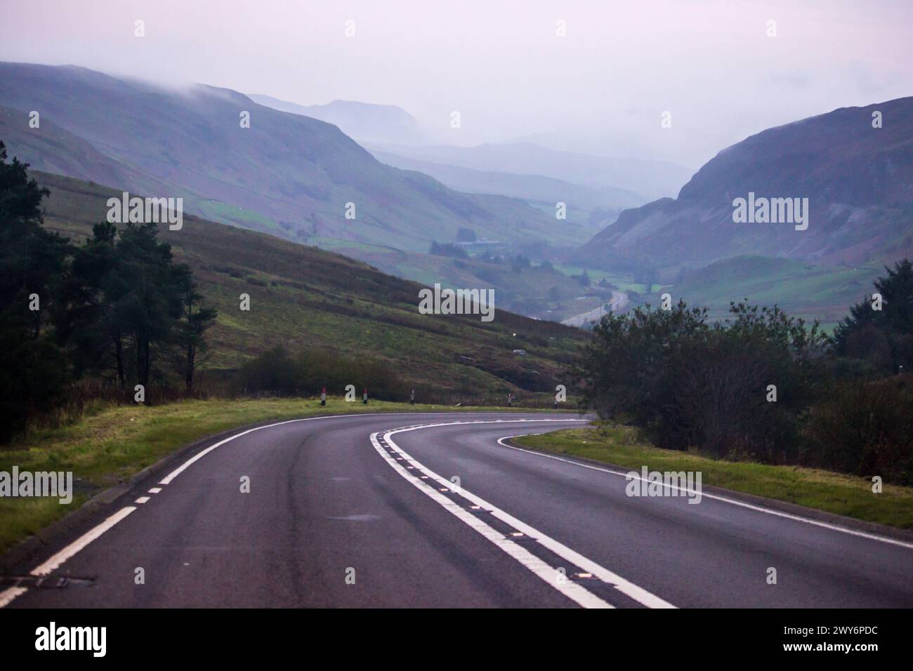 Road descending down into a mysterious misty valley in Eryri National ...