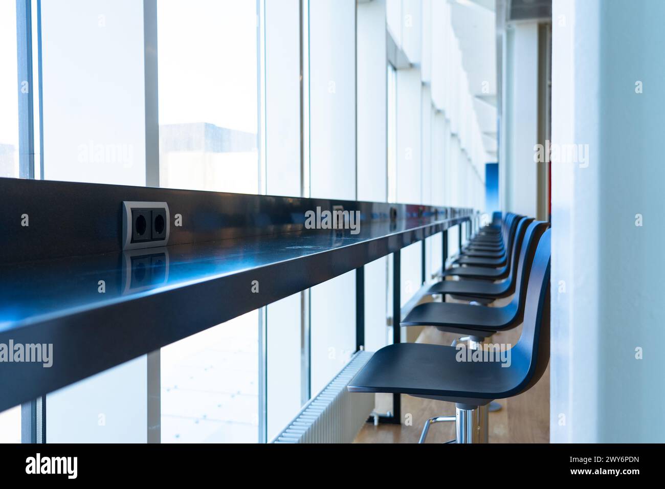 Airport waiting room with high chairs and a bar table and a bay window ...