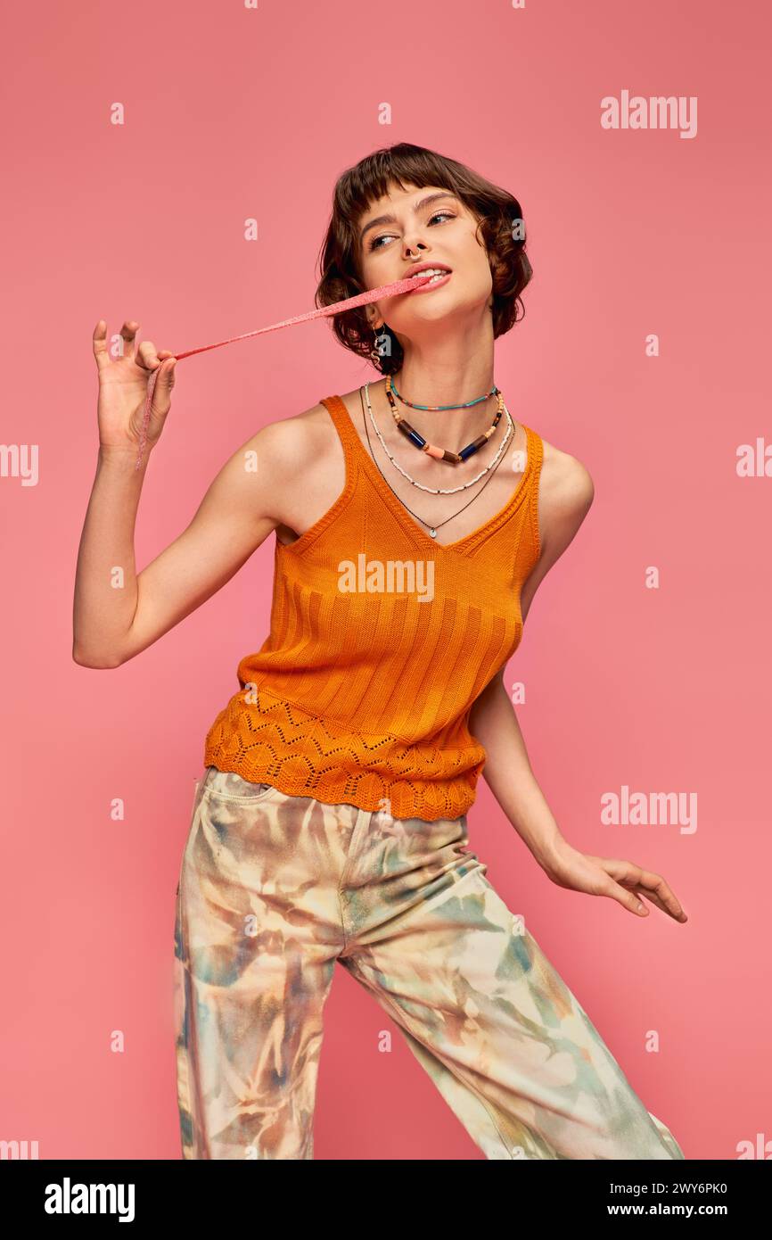 expressive girl with piercing and white teeth biting sweet and sour ...