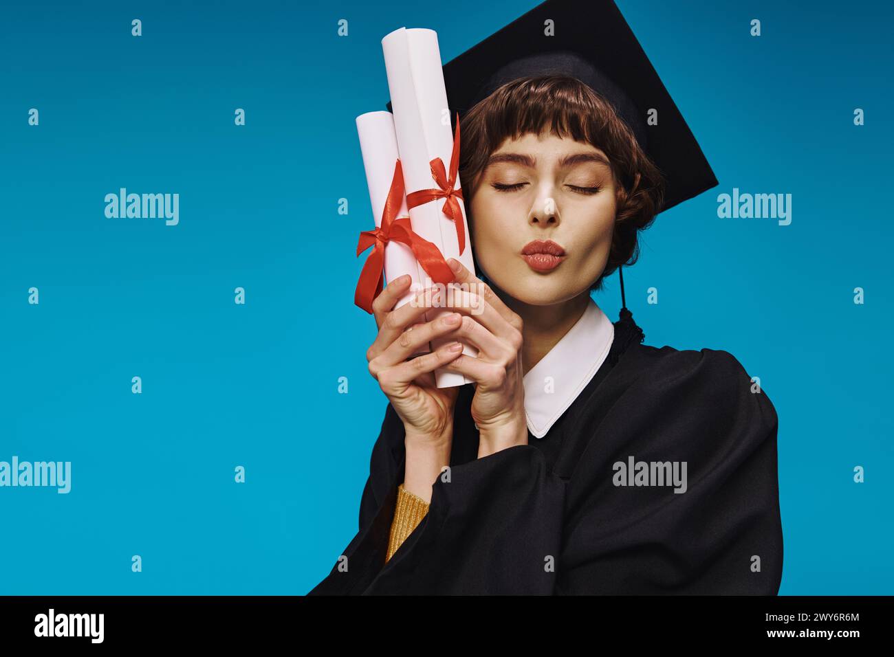 happy grad college girl in gown and academic cap holding diplomas with ...