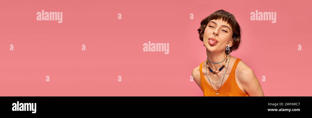 cheeky playful girl in 20s with short brunette hair sticking tongue out ...