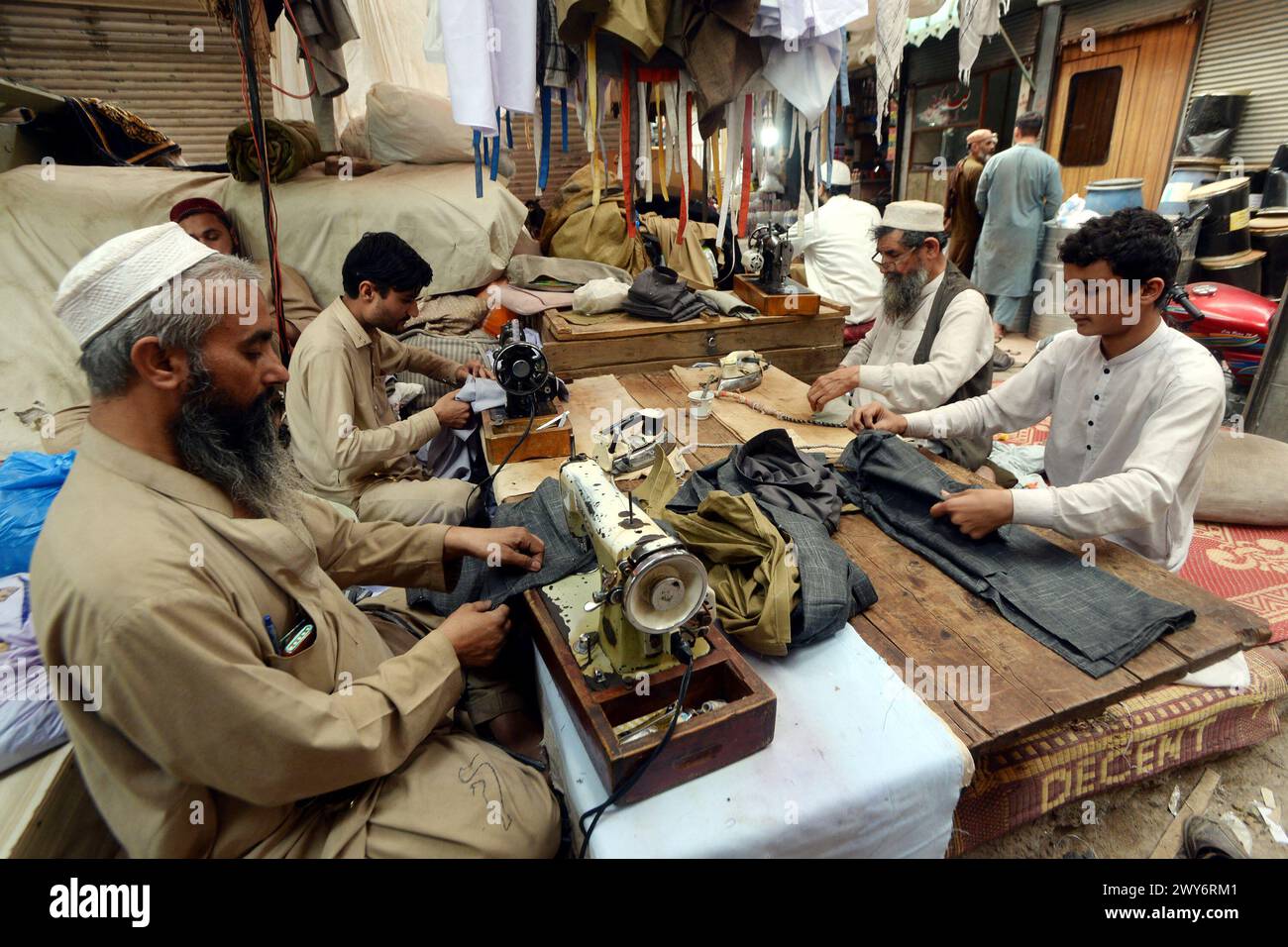 Peshawar. 4th Apr, 2024. Tailors stitch clothes for the upcoming Eid al ...