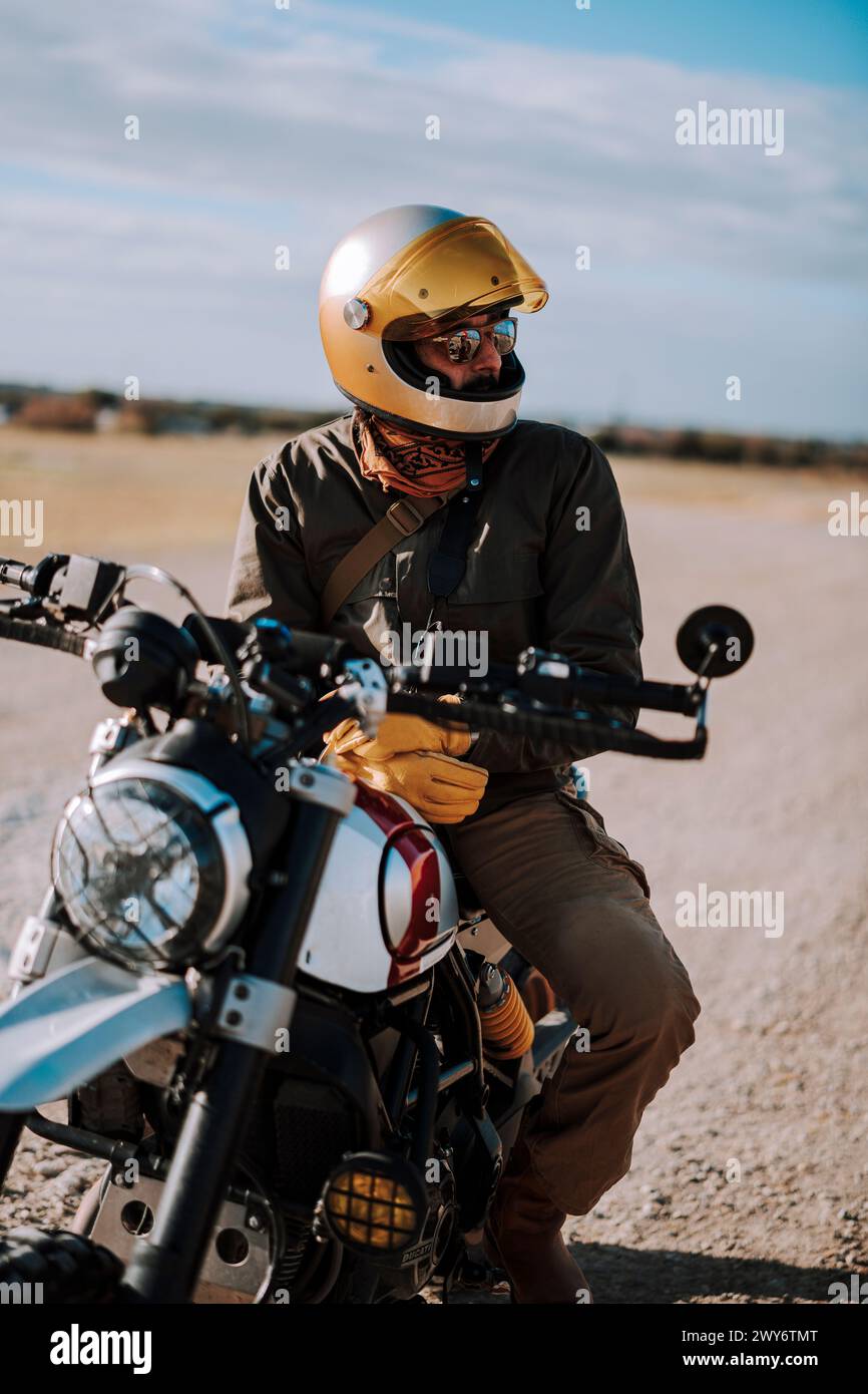 Man in helmet sits on motorcycle in desert Stock Photo - Alamy