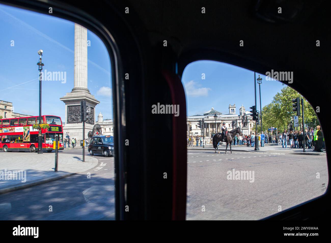 A double decker bus driving down a city street in London, England ...