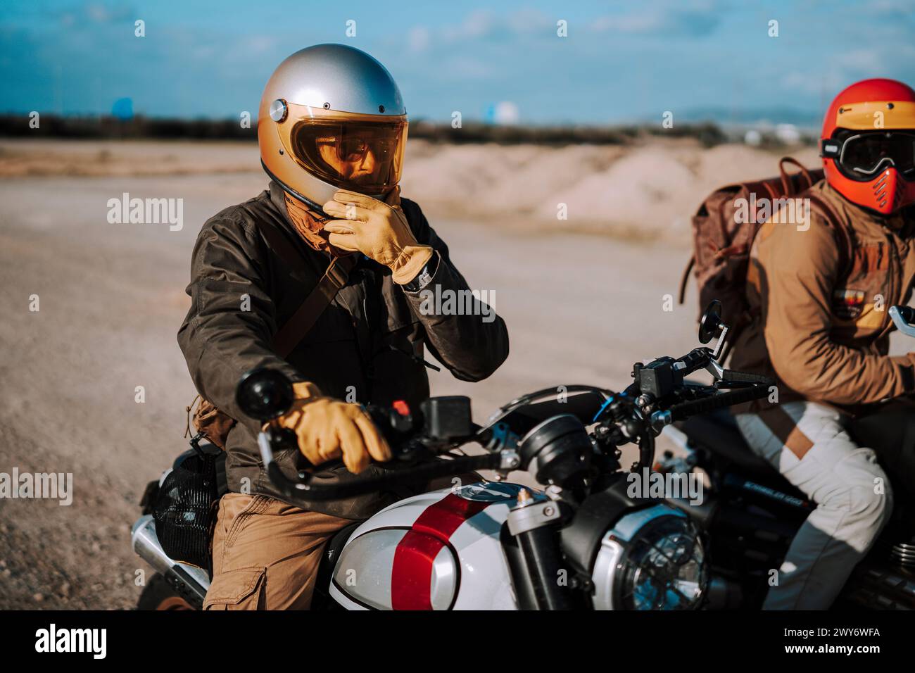 Two men in helmets and jackets on a motorcycle Stock Photo - Alamy