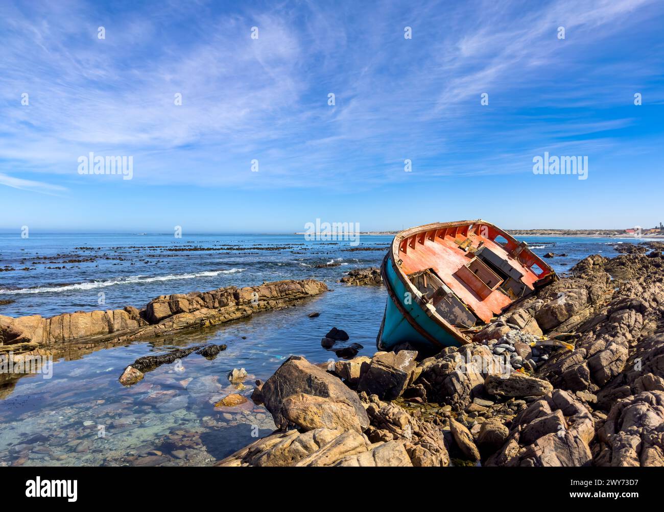 Shipwrecked diamond mining vessel on rocky shoreline in small West ...