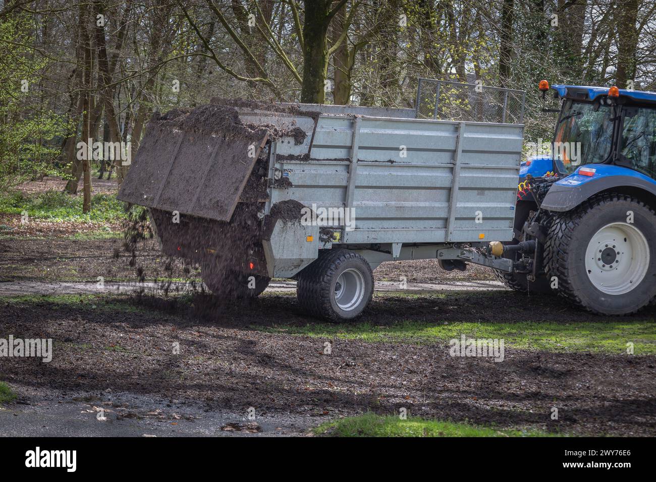 A tractor with a manure spreader to spread organic composted green ...
