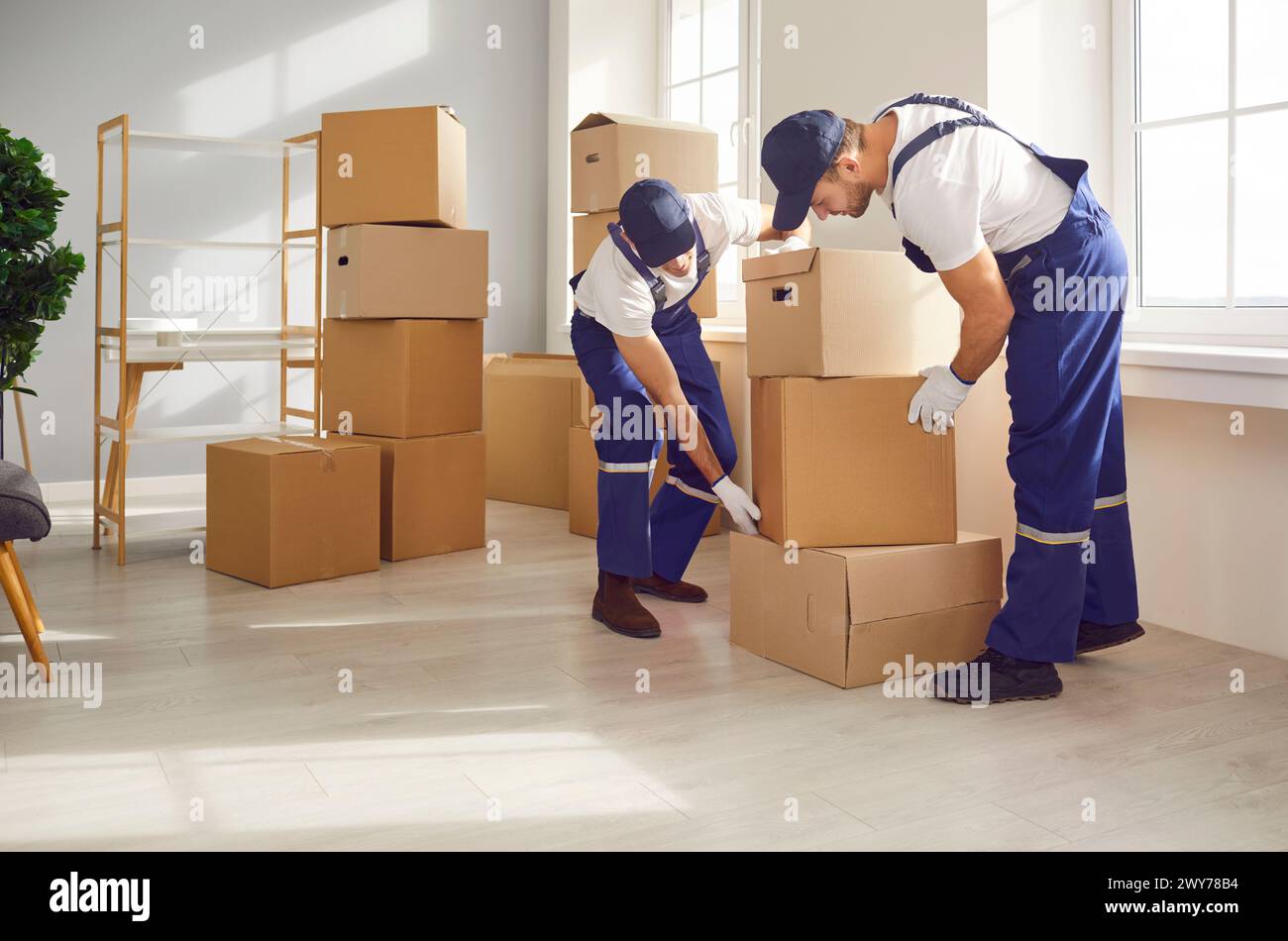 Workers from home removals company removing packed up boxes from house ...