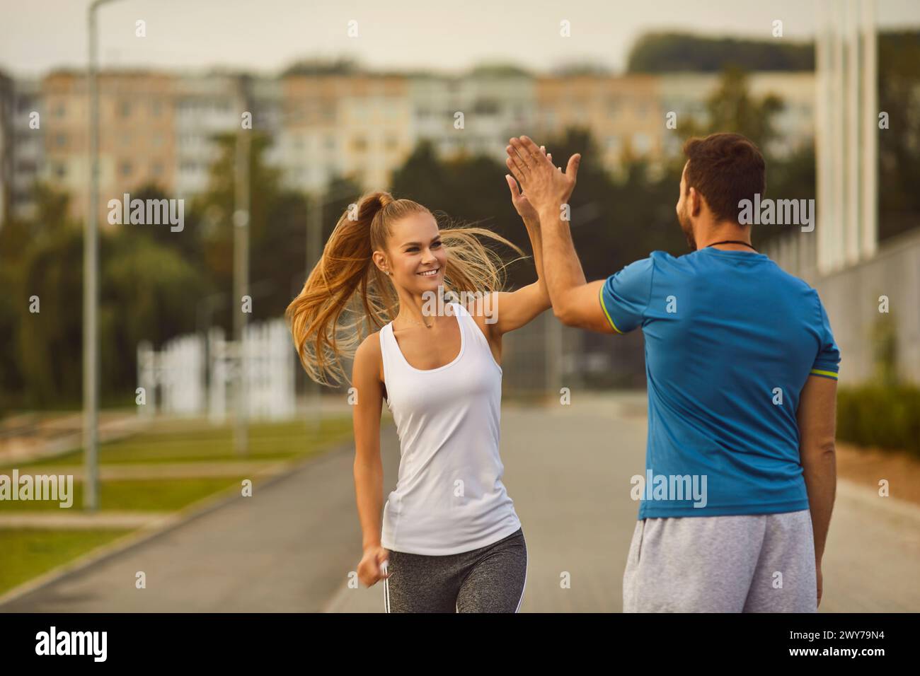 Woman Giving High Five to Male Coach During City Park Workout Stock ...