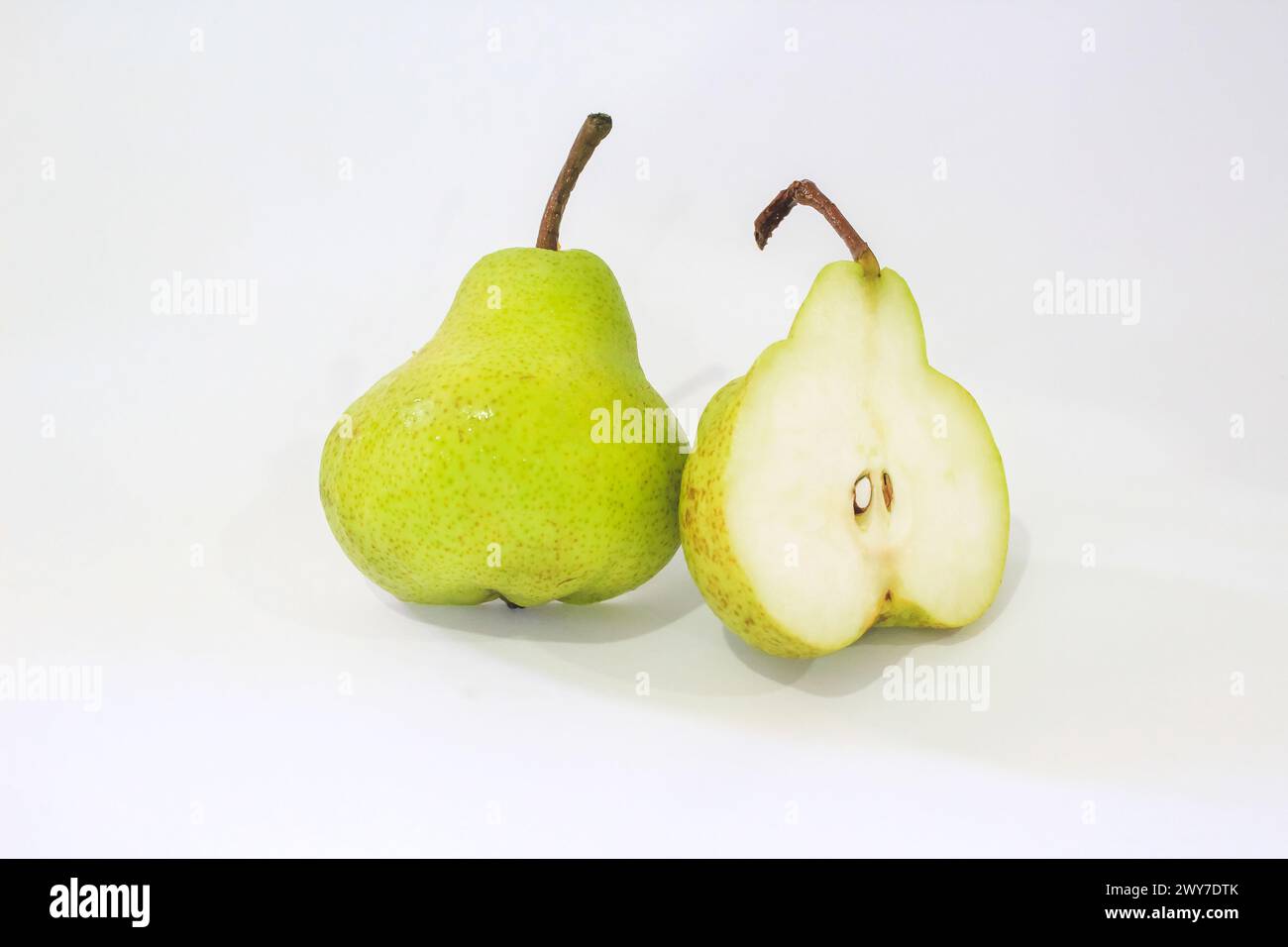 A delicious Pear isolated. One whole green pear and a half of fruit on ...