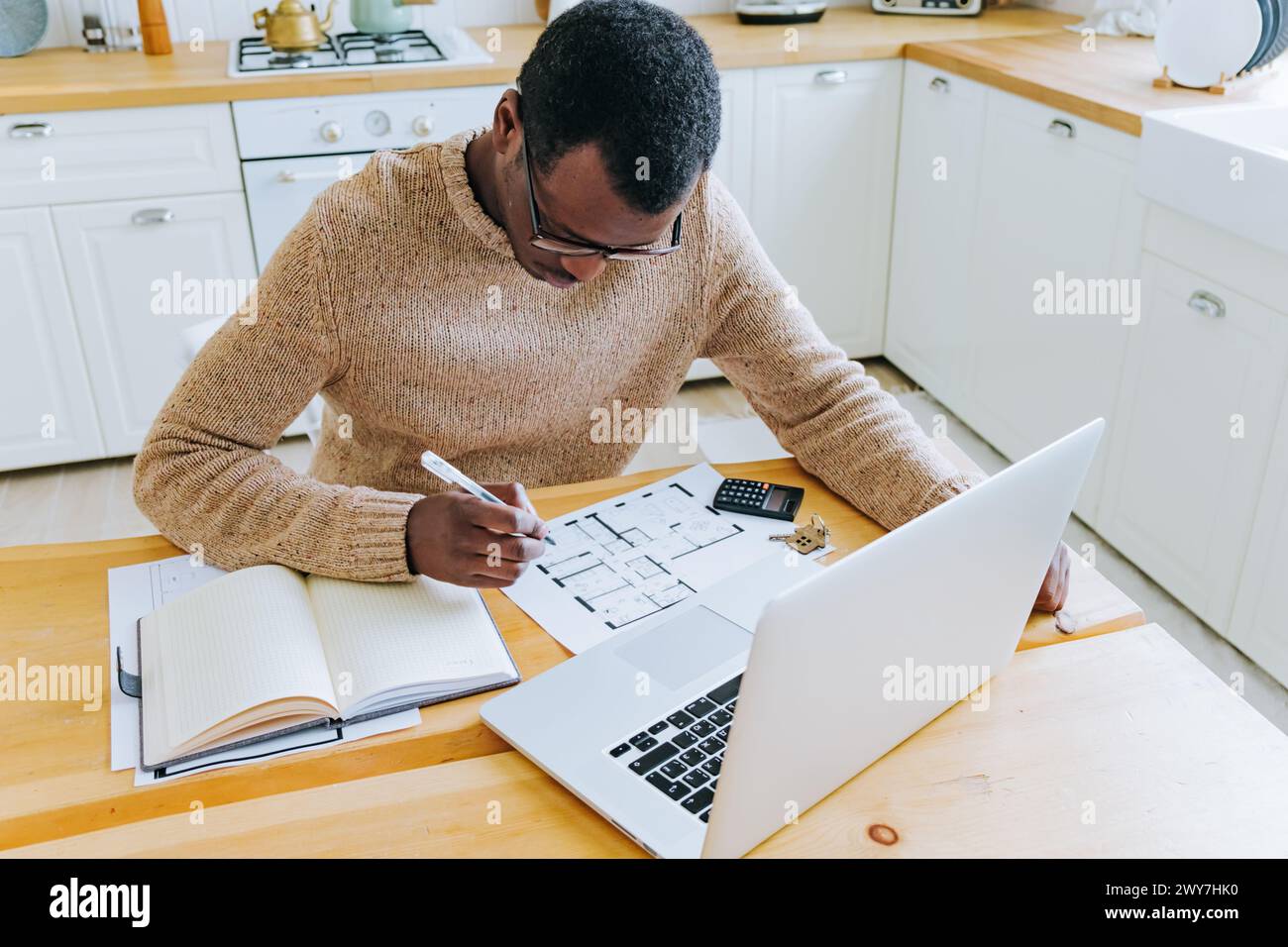 Focused African American Man Analyzing House Blueprints Next to Laptop ...
