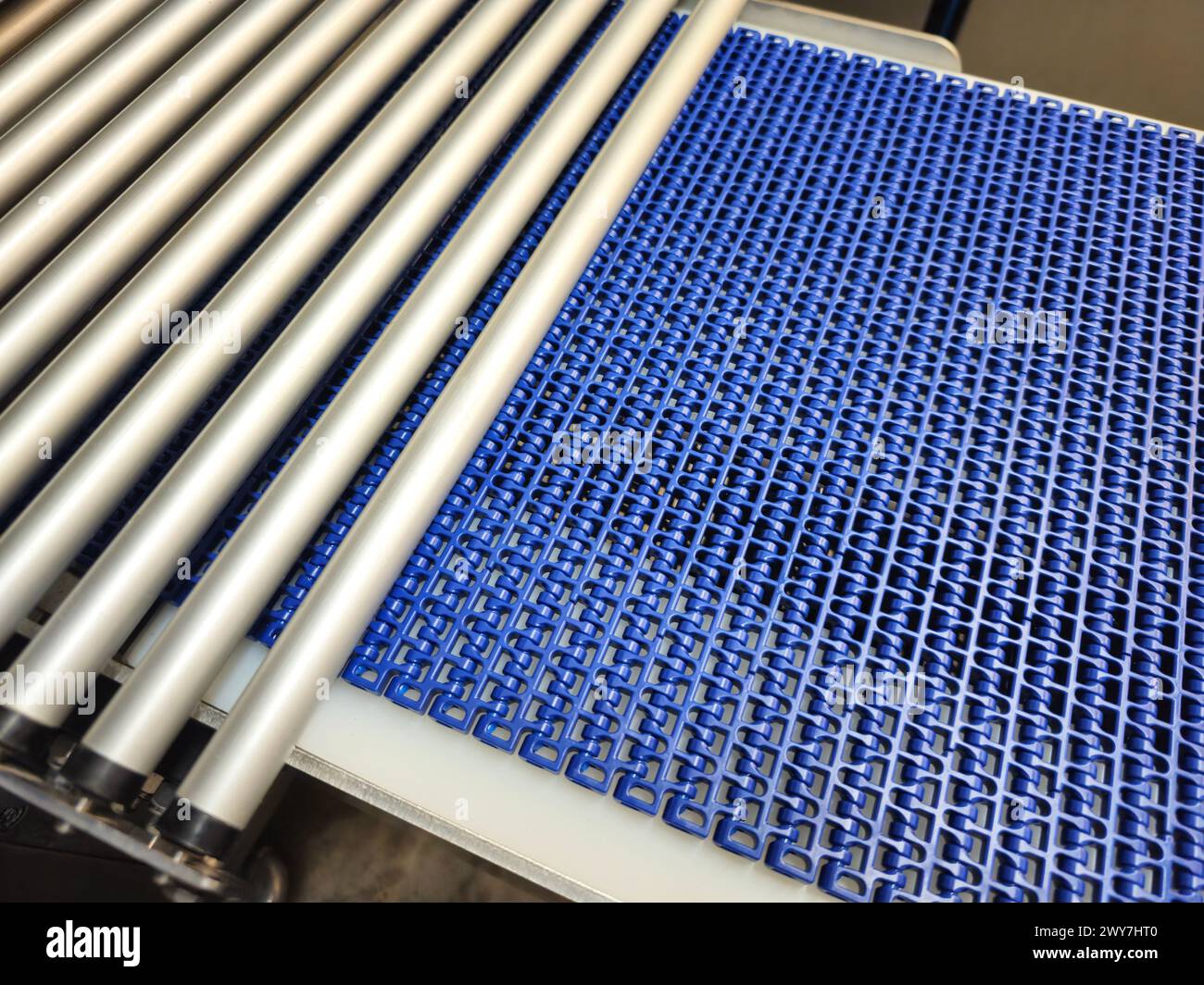 A close-up of a blue polyurethane belt in modular industrial conveyor ...