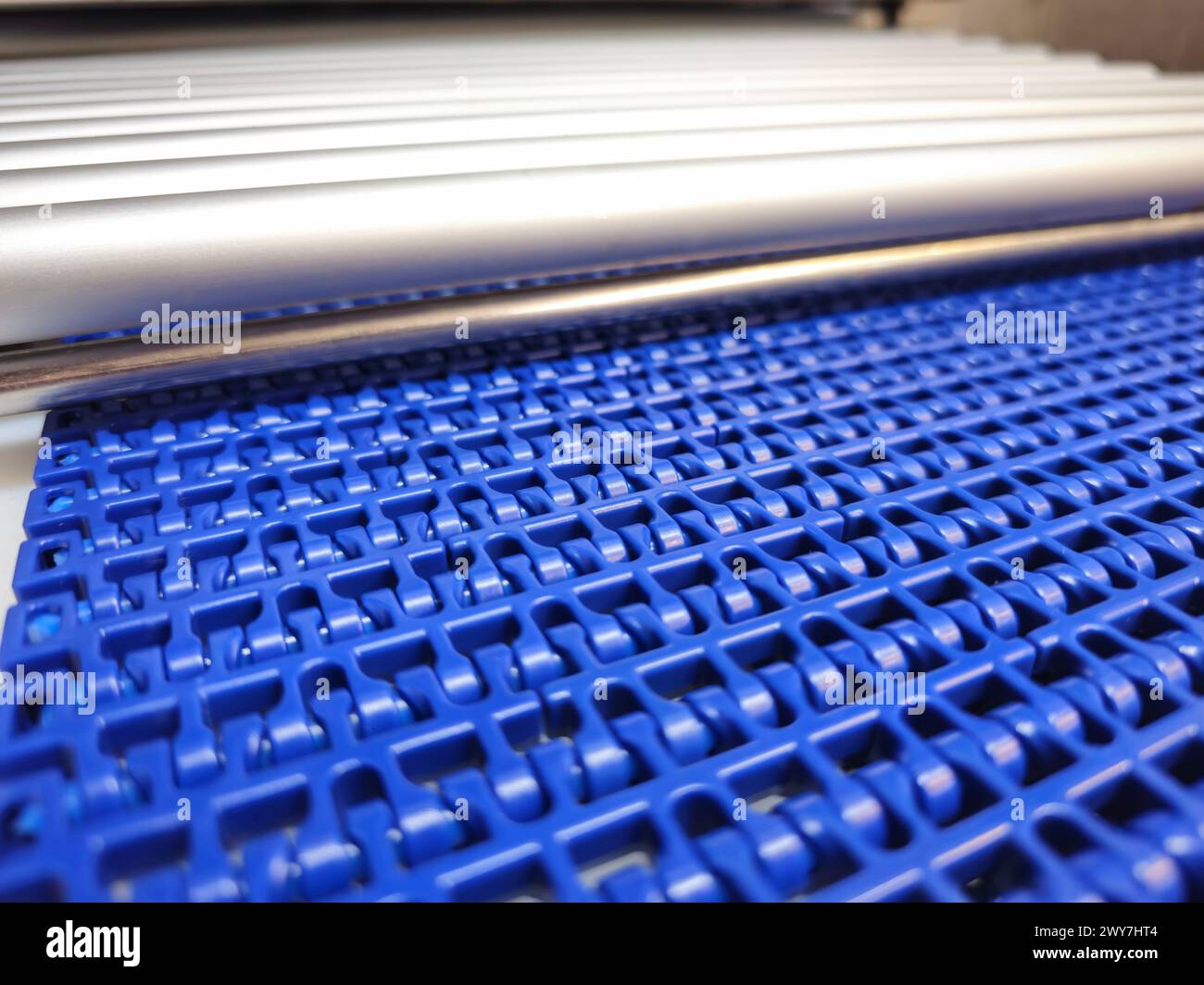 A close-up of a blue polyurethane belt in modular industrial conveyor ...